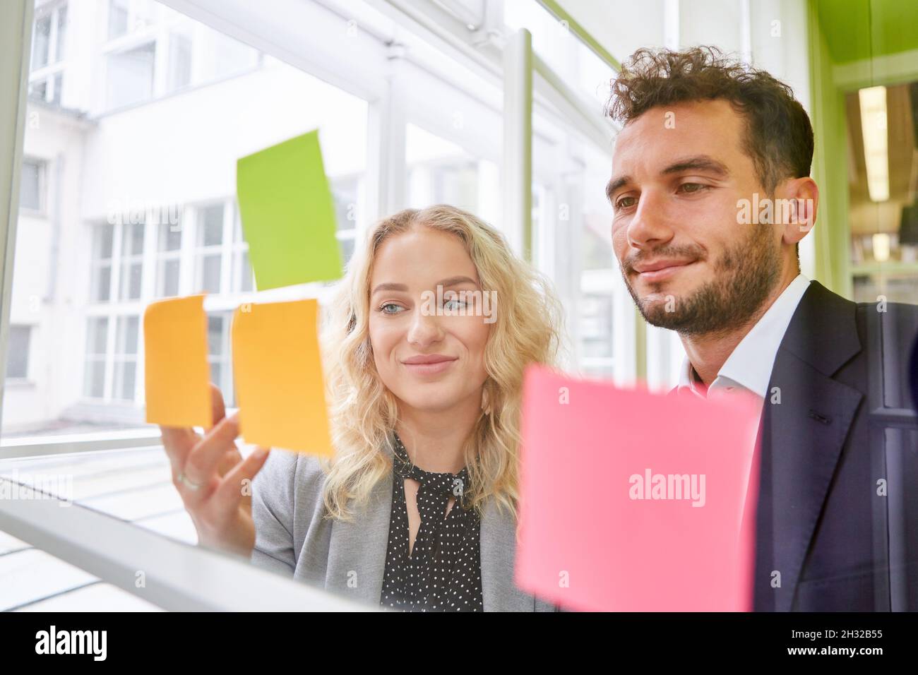 Business people evaluating ideas on sticky notes in brainstorming ...
