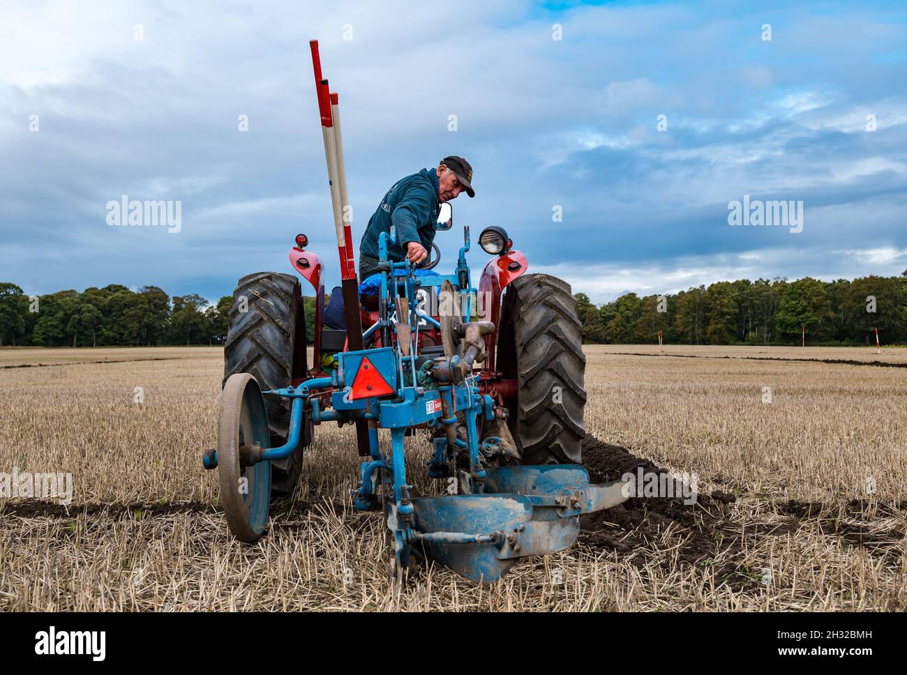 Man driving vintage tractor in ploughing match in stubble field, East ...