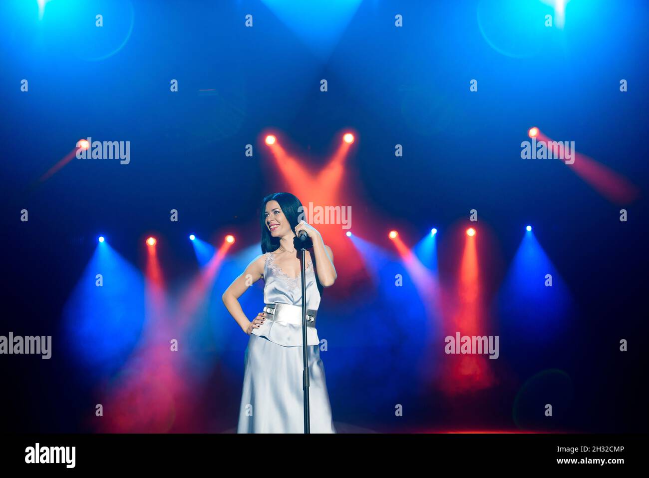 Bright stage lighting. Vocalist singing to microphone Stock Photo - Alamy