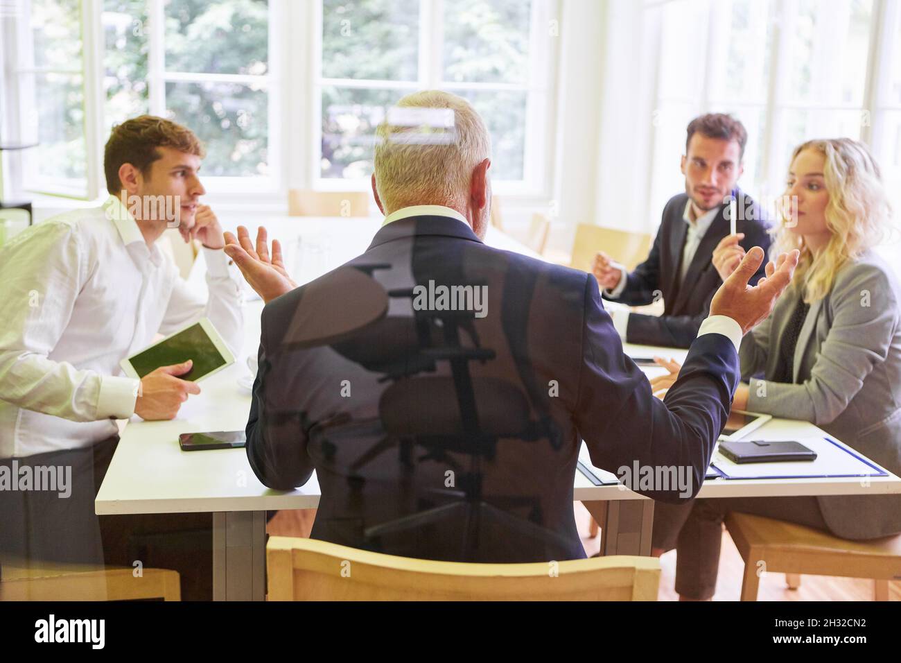 Consulting man or manager discusses with business people in a meeting ...