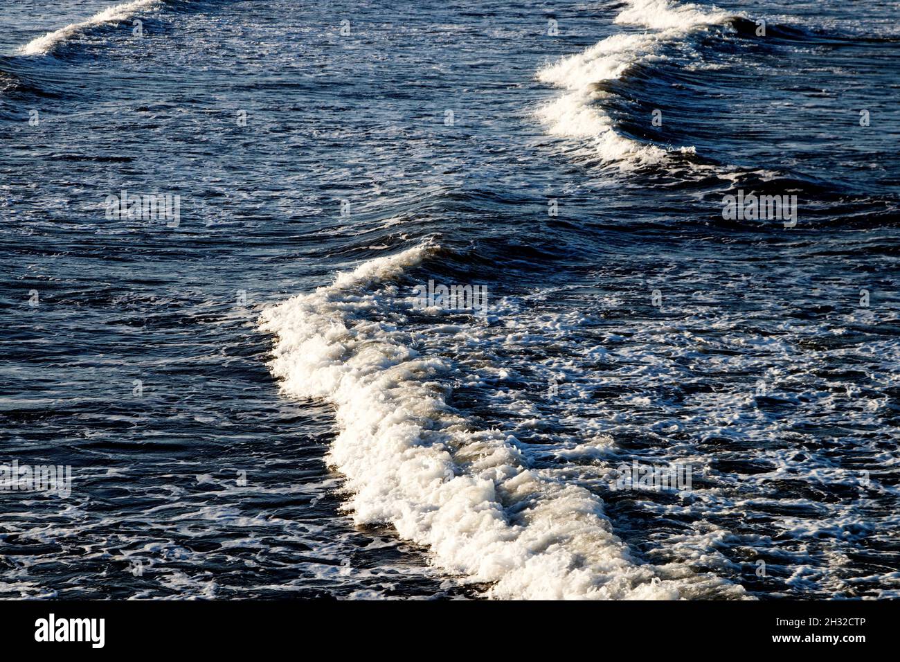 Closeup view of white breaking waves during an incoming tide at a beach ...
