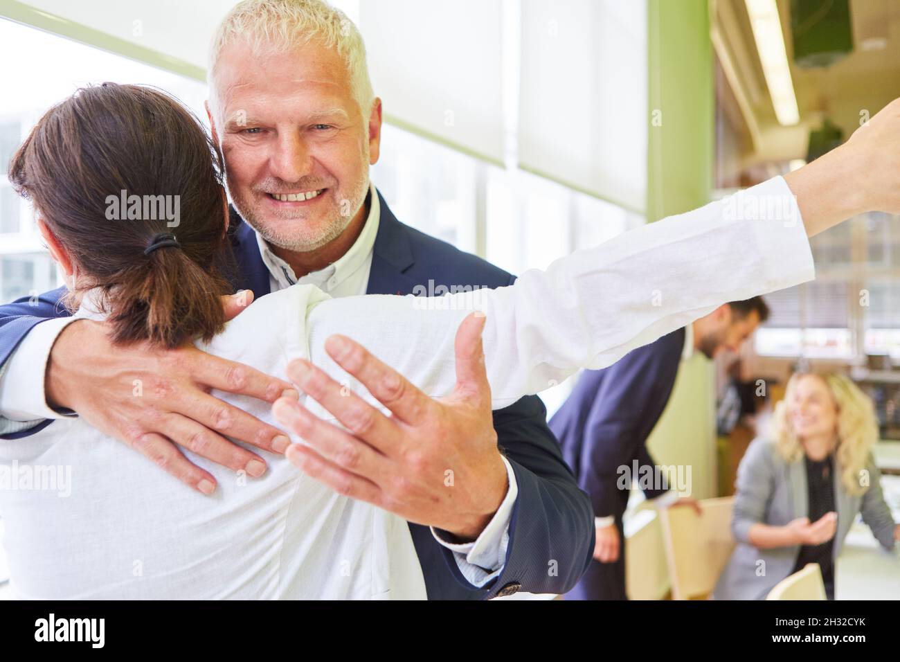 Business man and colleague hug each other and celebrate success and ...