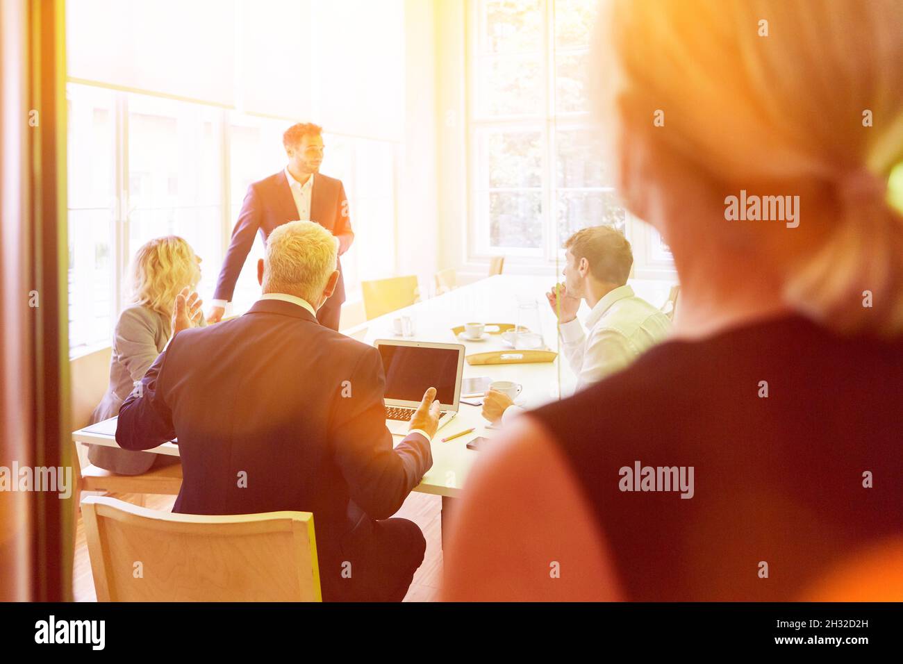 Group of business people talking to each other at business meeting in ...