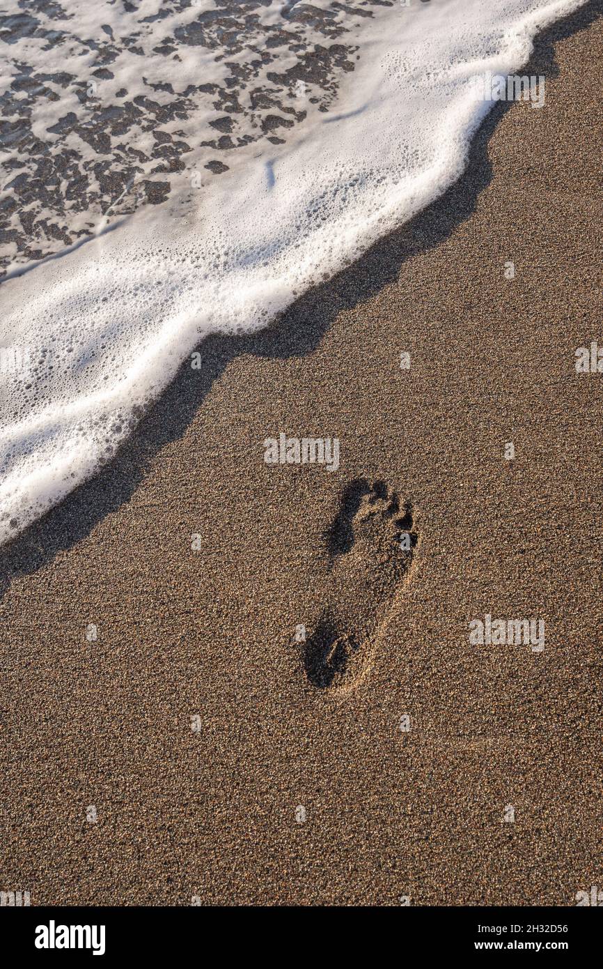 Footsteps in the sand on the beach, vertical Stock Photo - Alamy