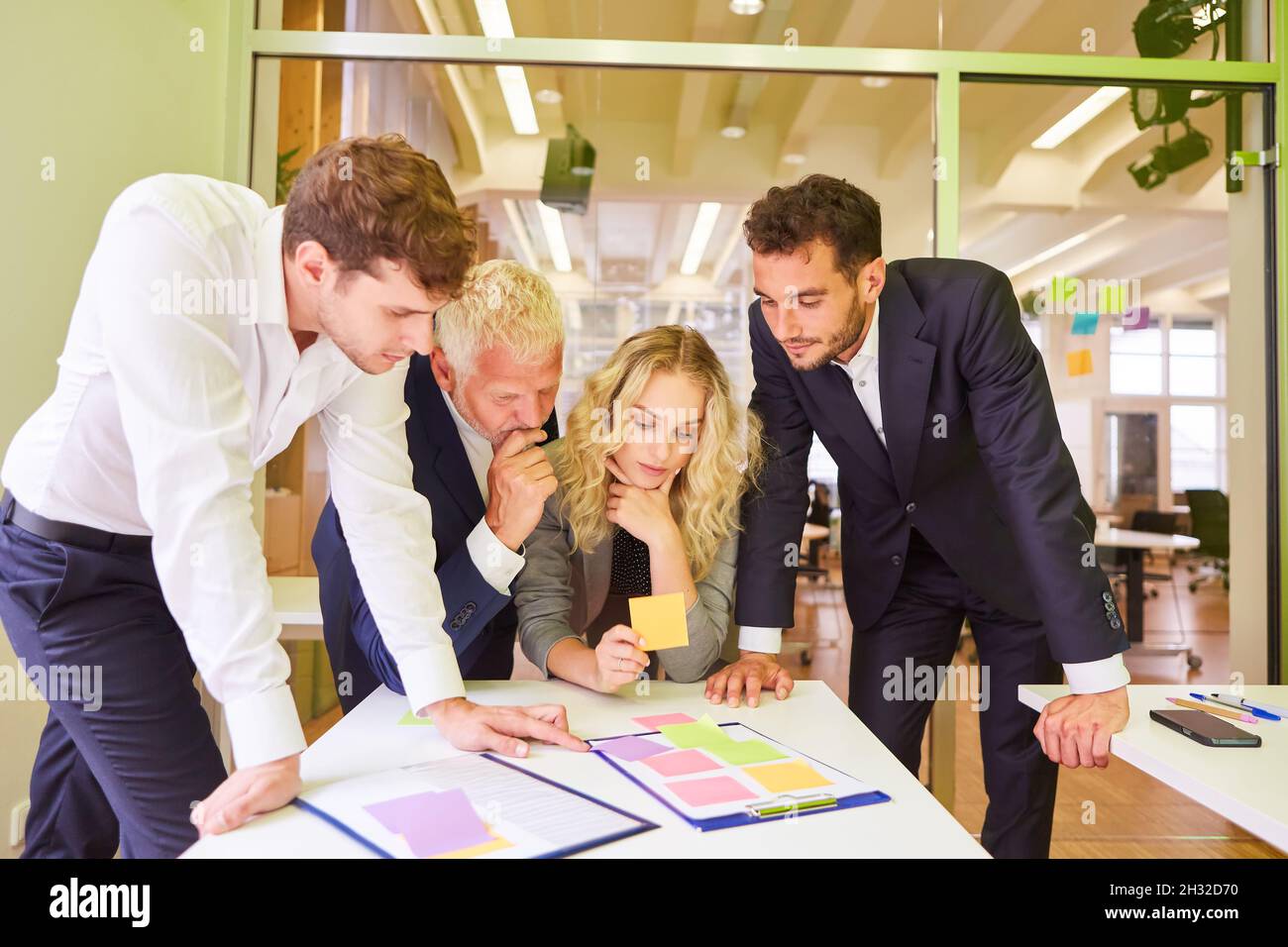 Business people plan a project together using sticky notes in the ...