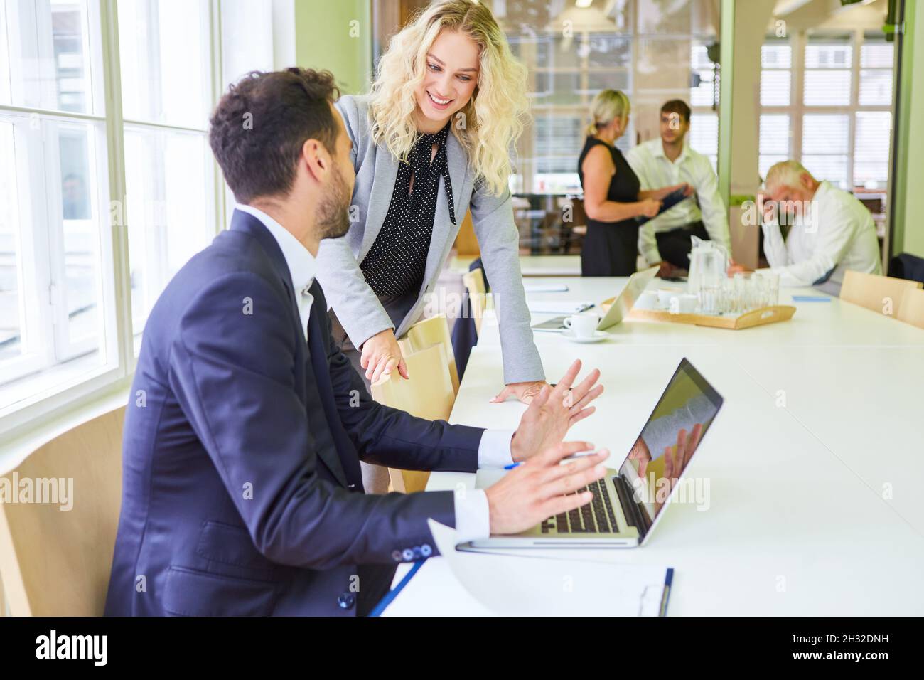 Two business people are working together on laptop computer in ...