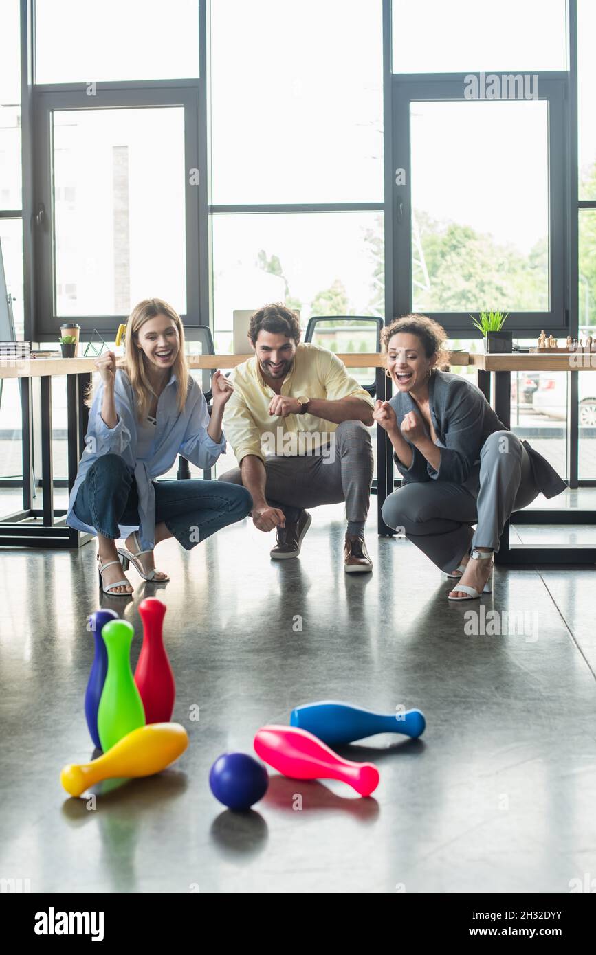 Positive multiethnic business people playing bowling in office Stock ...