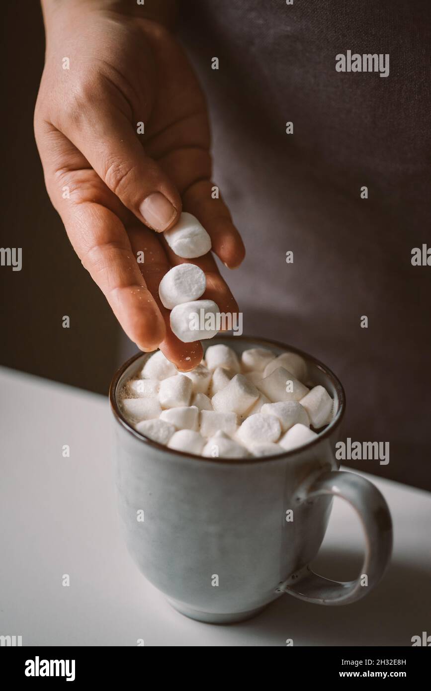Woman puts marshmallows in mug hi-res stock photography and images - Alamy