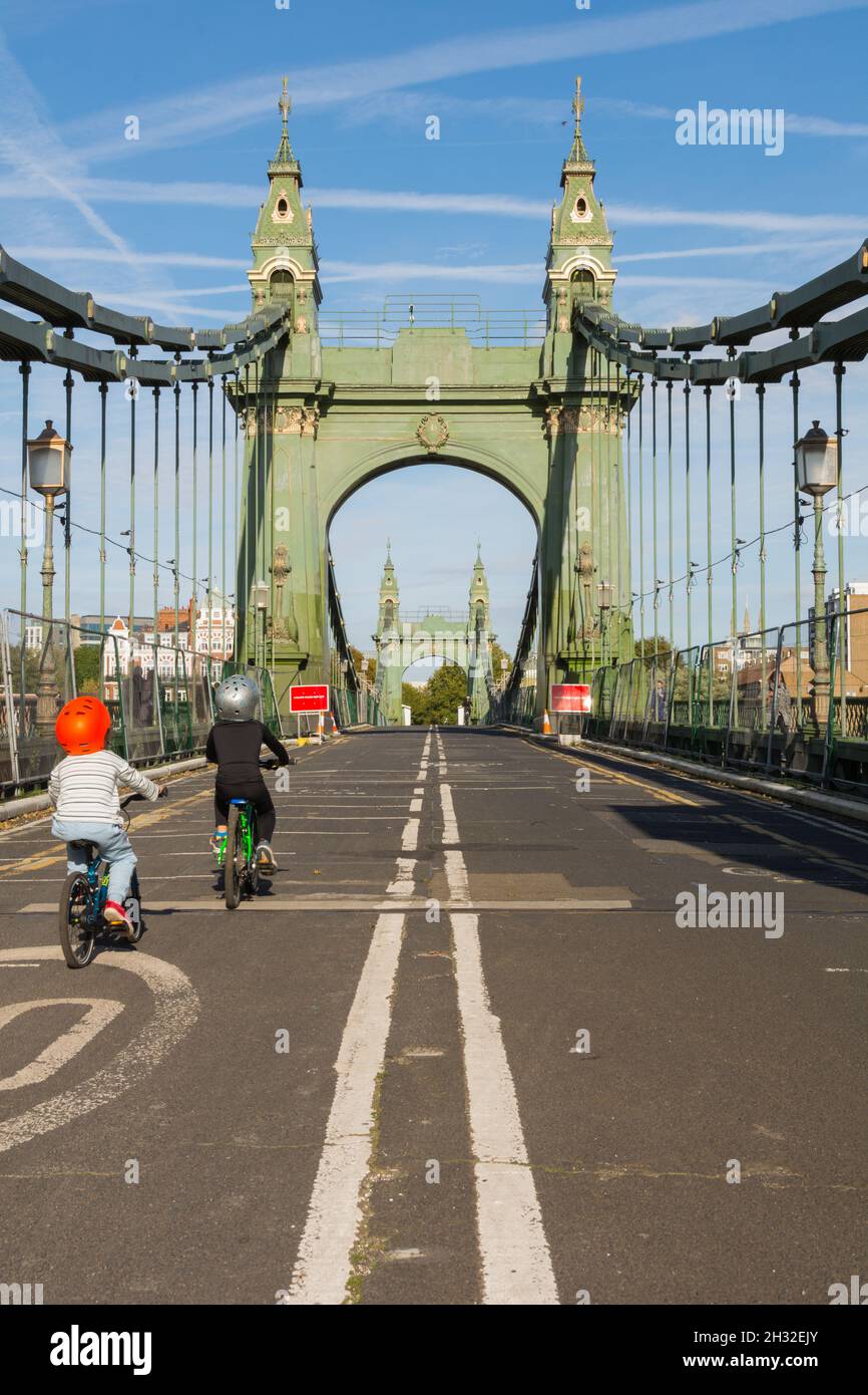 Toddlers cycling across Hammersmith Bridge in west London, England, U.K ...