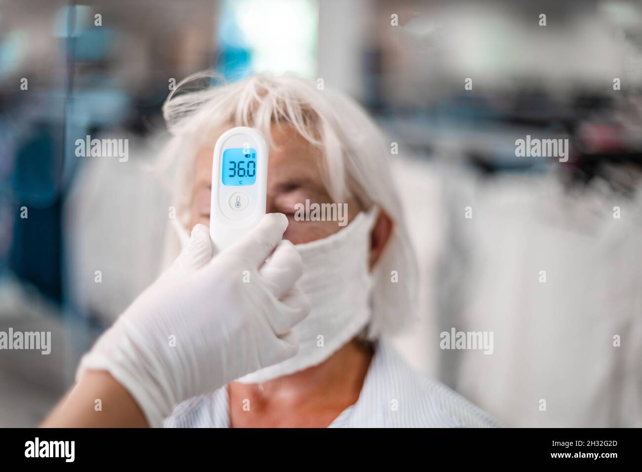 Hand holding infrared thermometer to measuring temperature on blurred ...