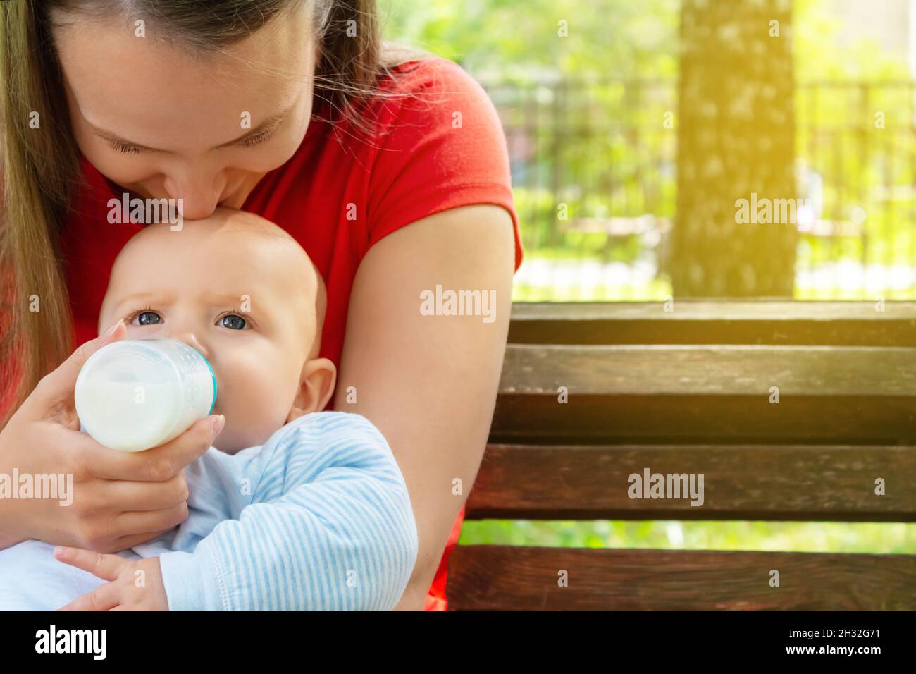 Mother with son drinking milk in park Stock Photo - Alamy