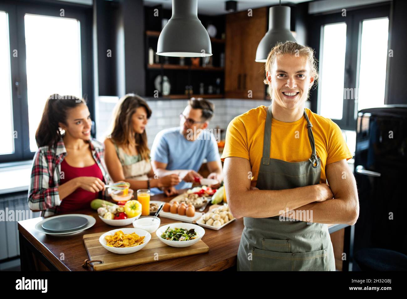 Beautiful happy people, friends is smiling while cooking together in ...
