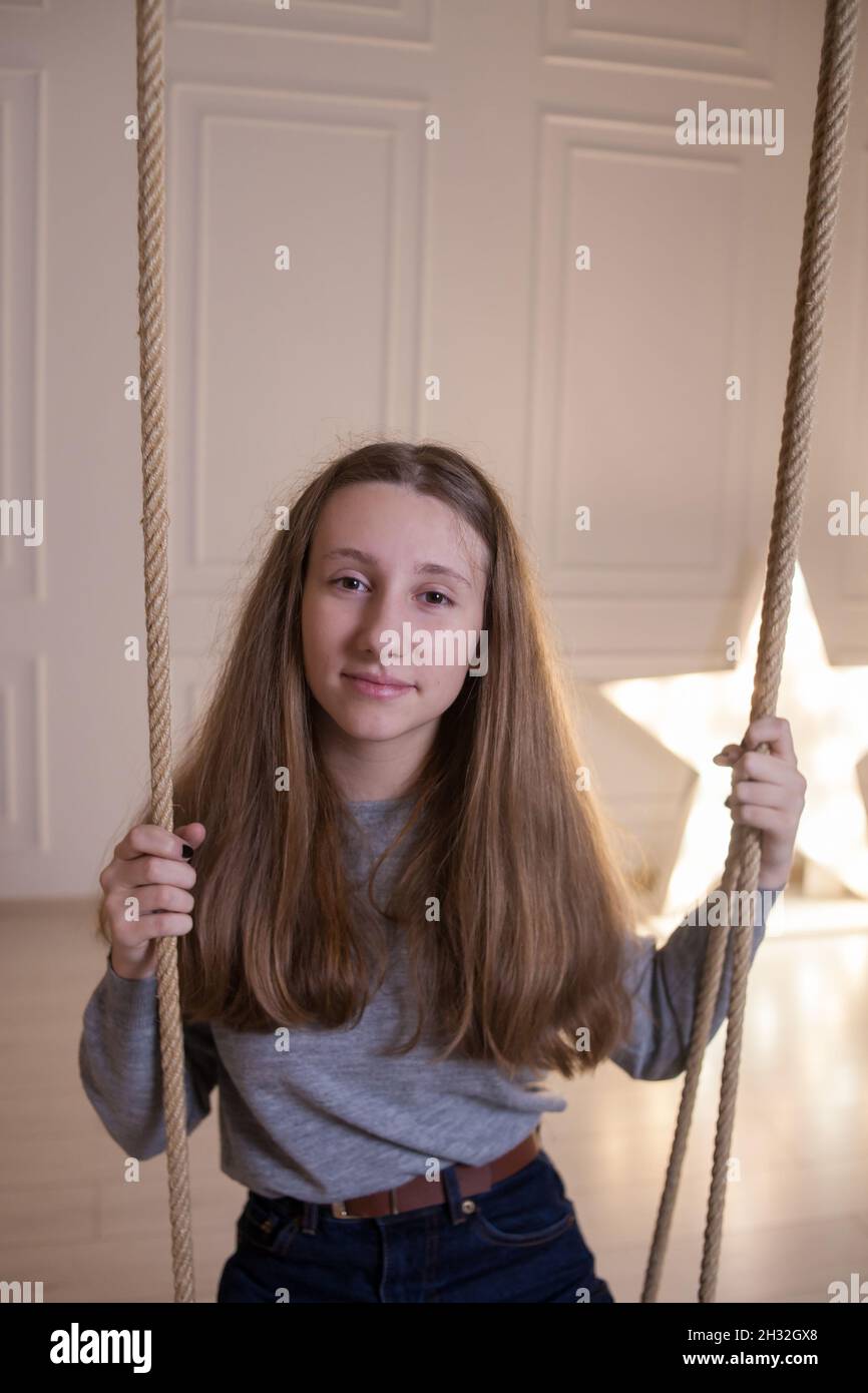 Cute happy girl with smile holding ropes on the swing chair Stock Photo ...