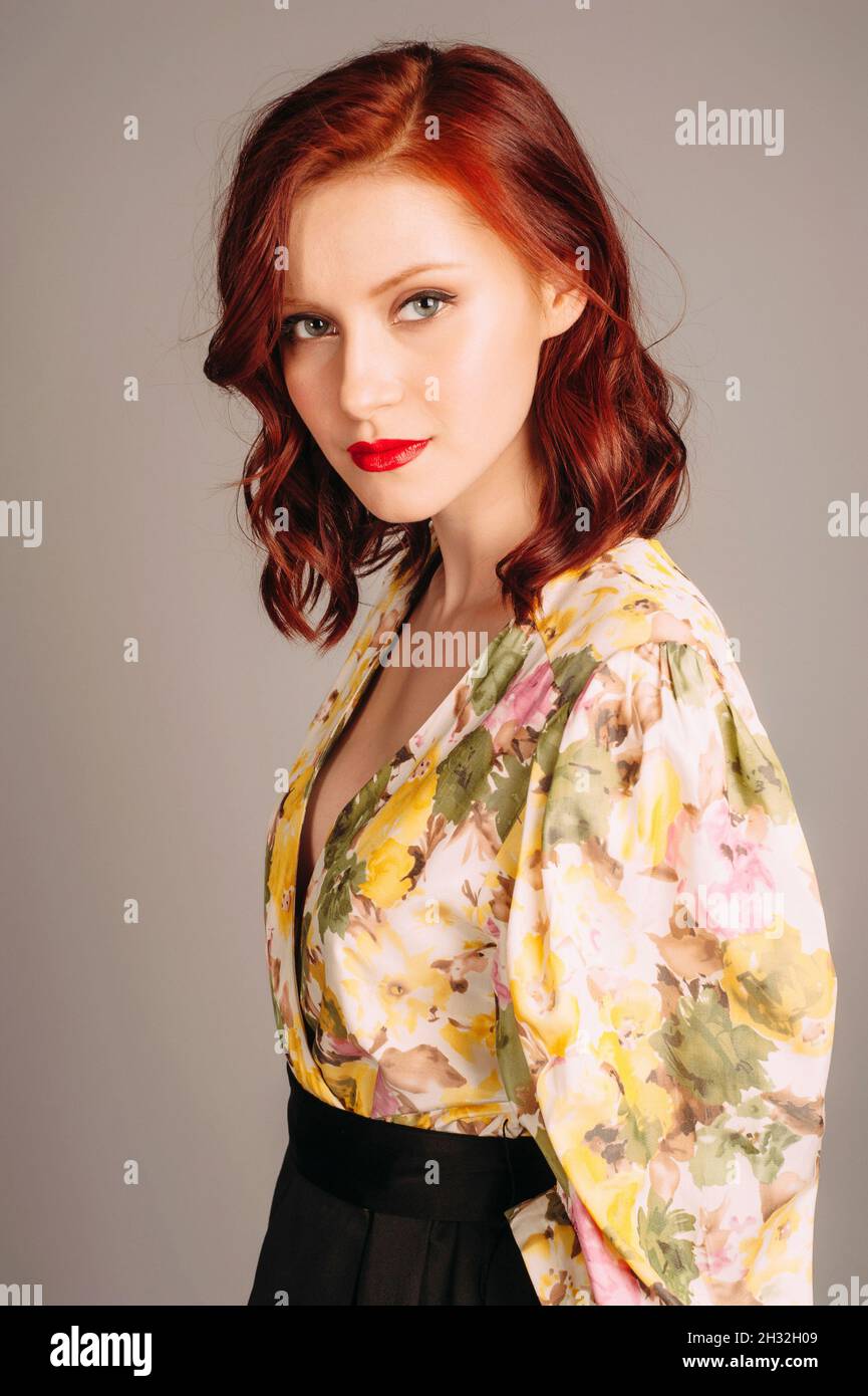 Female fashion. Redhead model in evening dress with long yellow balloon ...