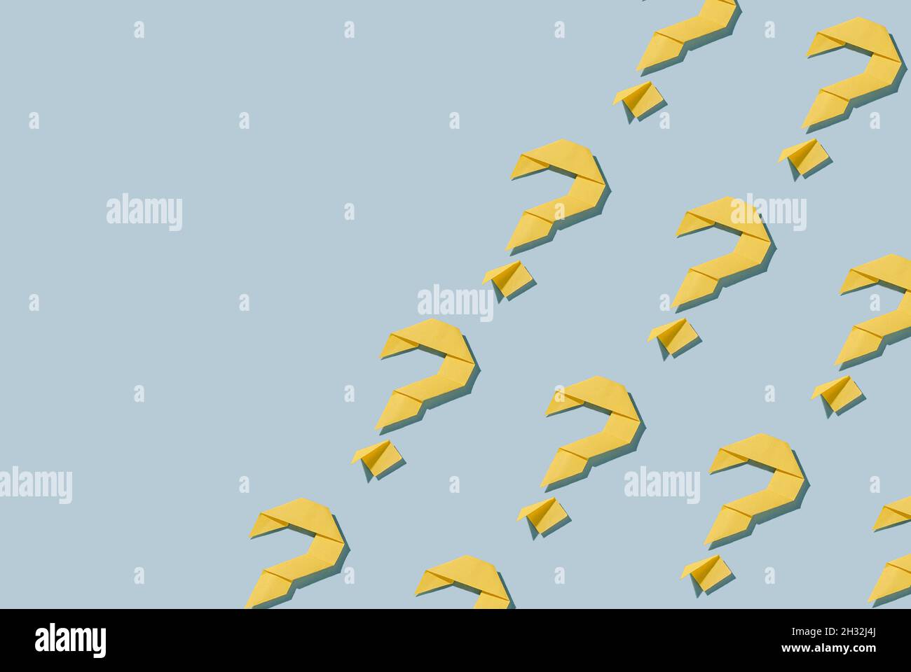 Repeat diagonal pattern of yellow paper origami question marks filling ...