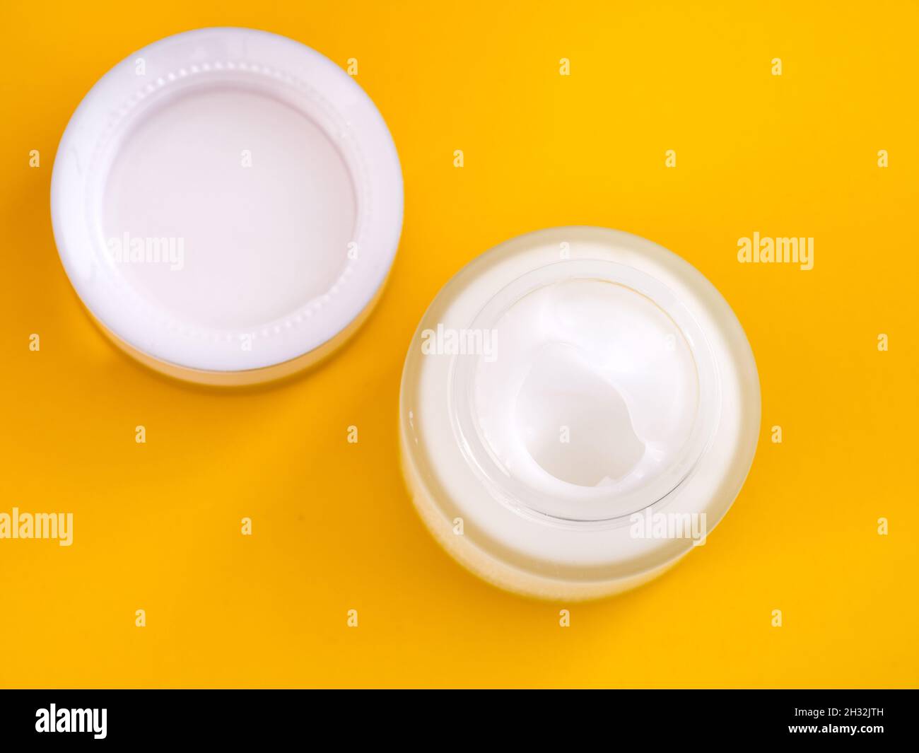 Face cream in an open jar on yellow background Stock Photo - Alamy