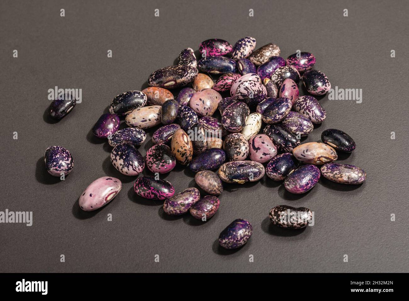 Assorted multicolored beans scattered on black stone background. Raw ...