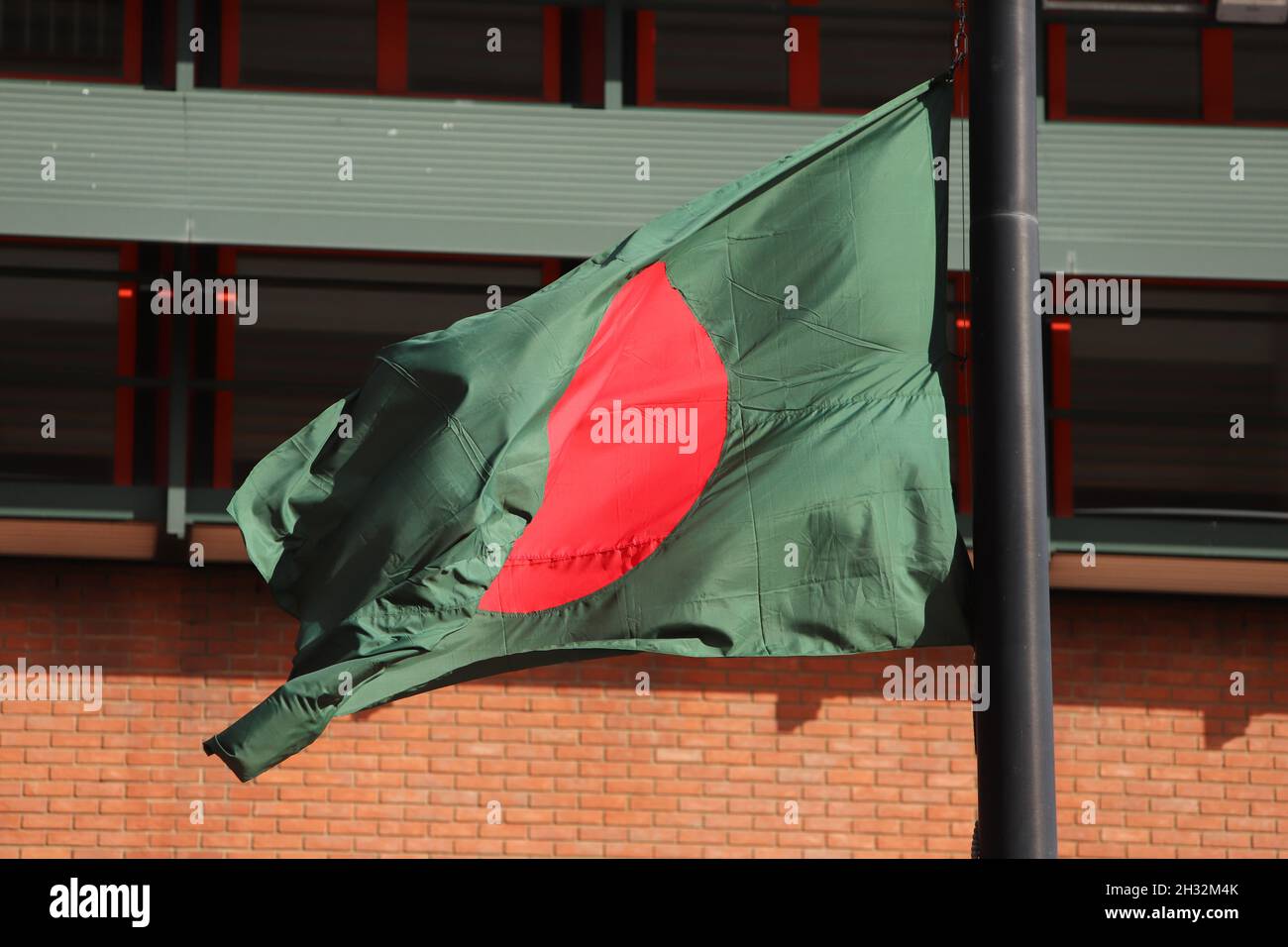 The Bangladeshi flag / flag of Bangladesh, flying outside a building ...