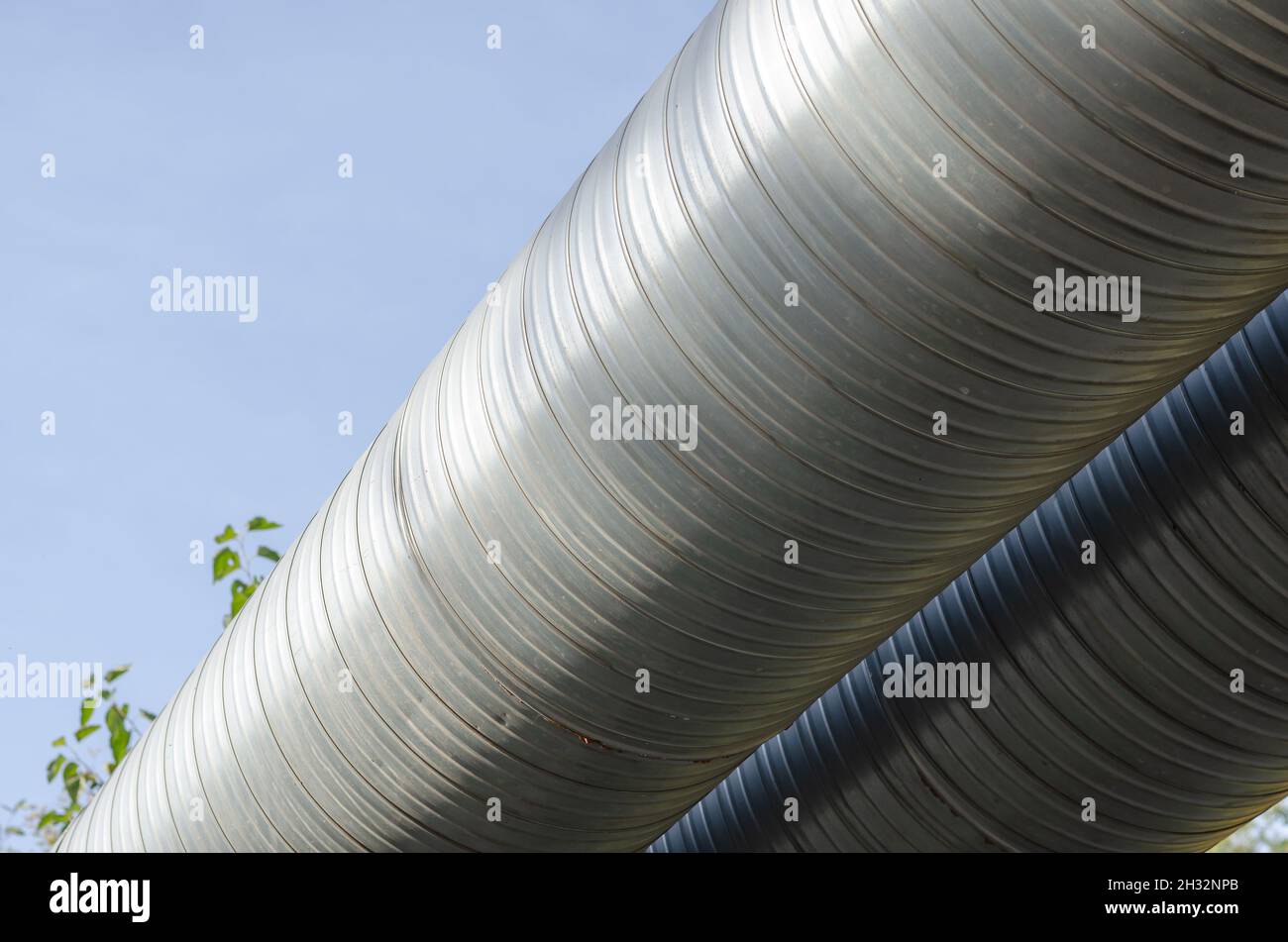 Pipeline against the sky. Two pipes covered with galvanized metal ...