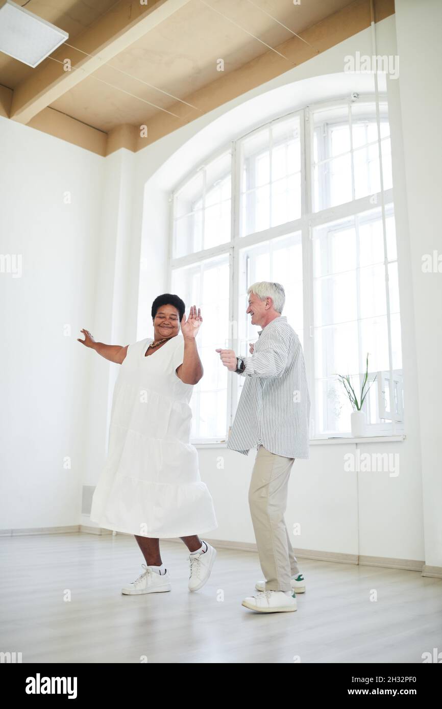 Happy African Woman Dancing Together With Senior Man During Dance