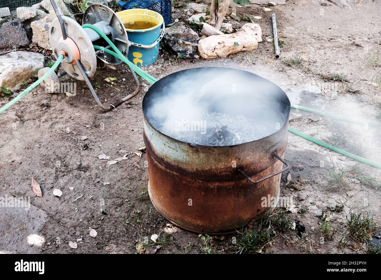 Burning leaf ashes and smoke in a metal barrel. Sanitary treatment of ...