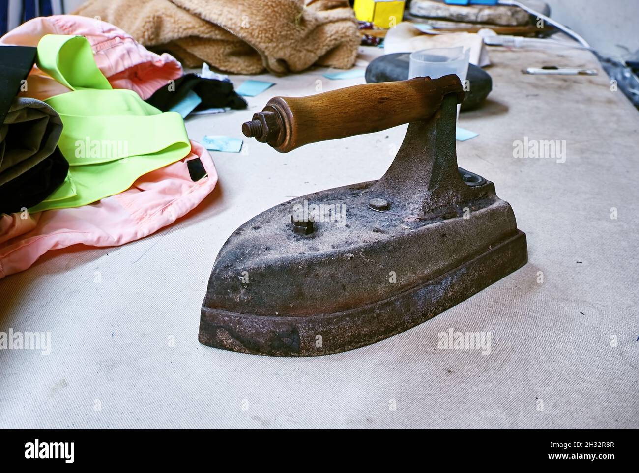 Rusty vintage iron on a tailor workbench Stock Photo - Alamy
