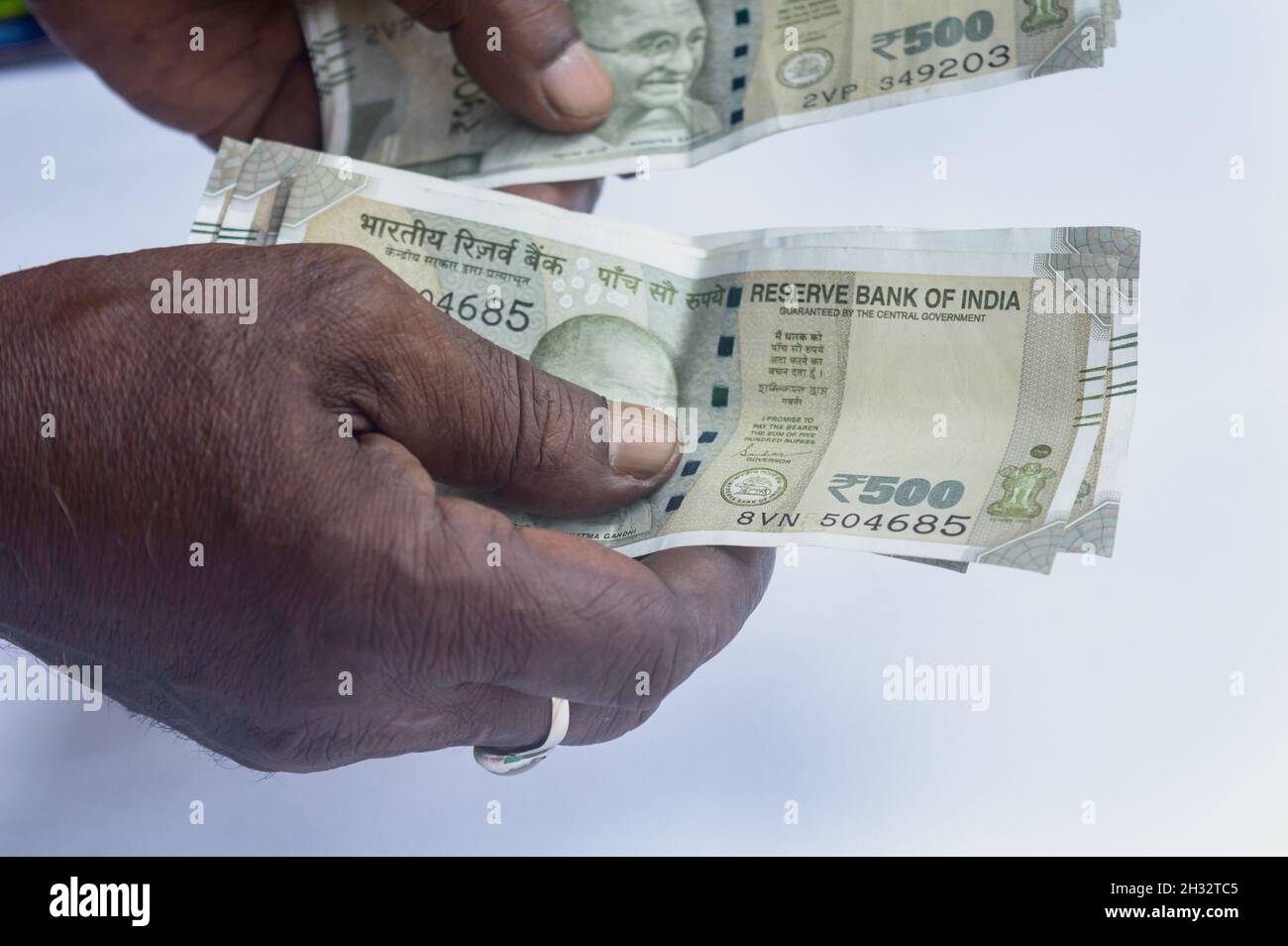 Senior aged Man hand counting Indian rupee note on table. High angle ...