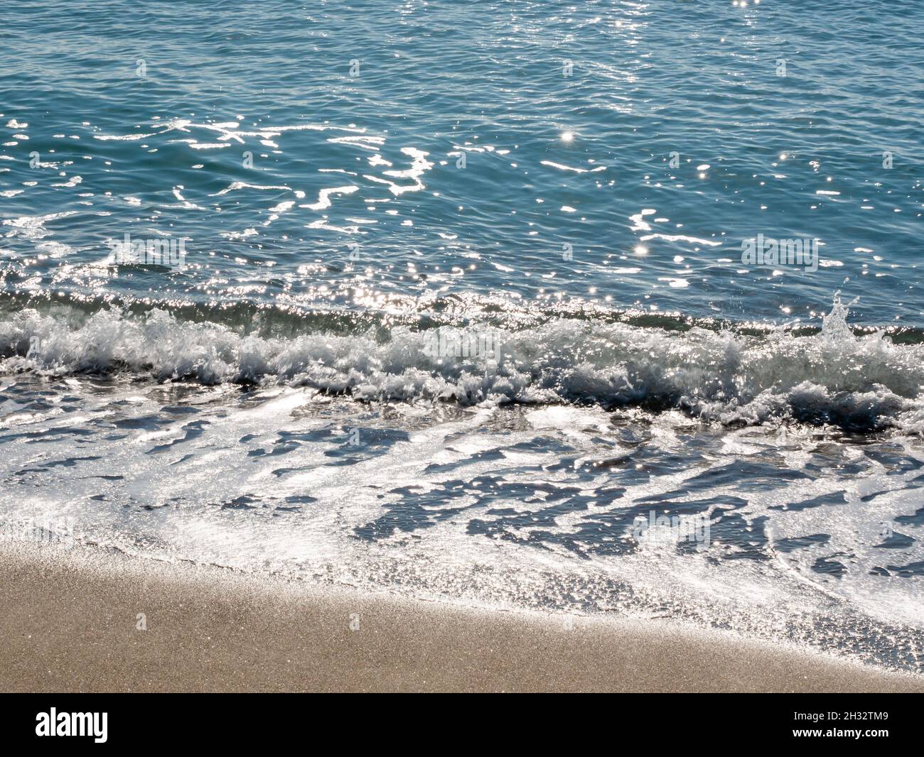 sea waves on the shore shine in the sunlight, concept of calm and peace ...