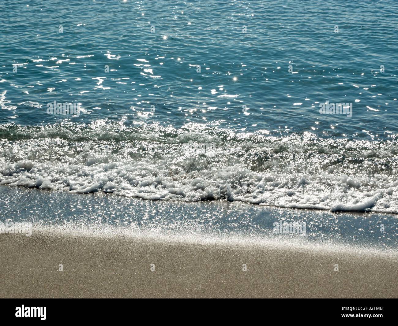 sea waves on the shore shine in the sunlight, concept of calm and peace ...