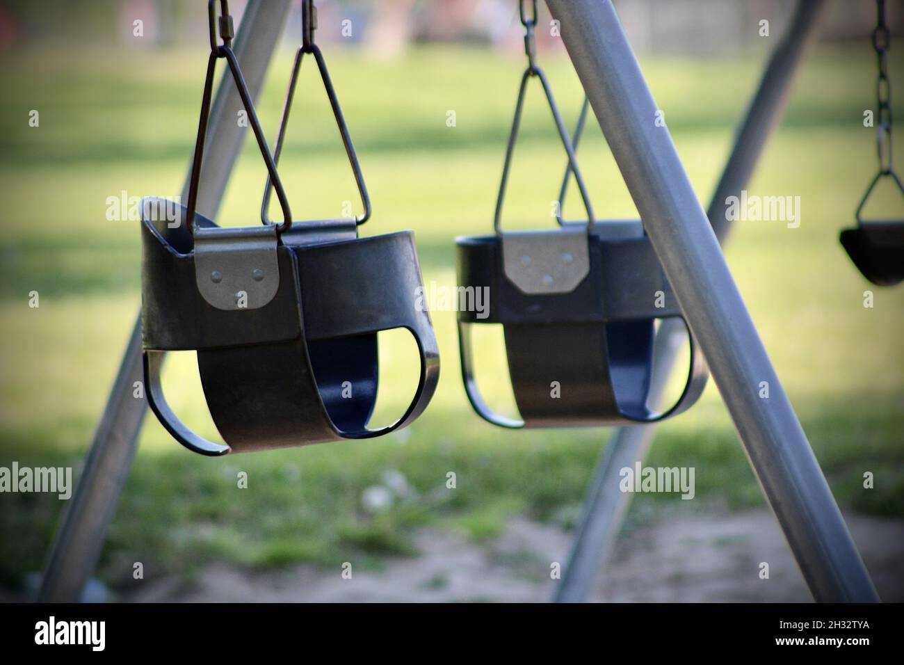 Selective of two swings in a playground Stock Photo - Alamy