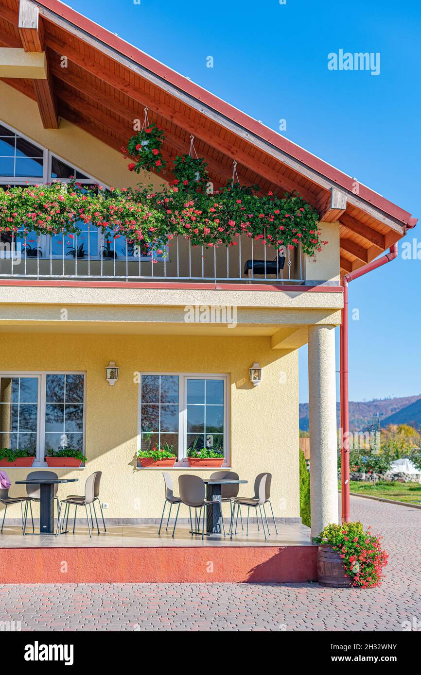 Part of the house with a beautiful terrace and a balcony with flowers ...