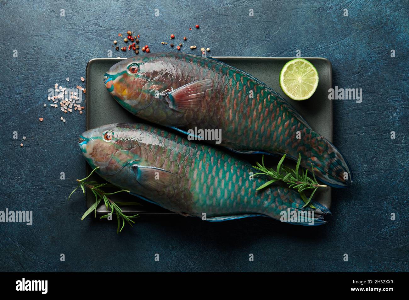 Fresh raw parrot fish cooking on blue stone background Stock Photo - Alamy