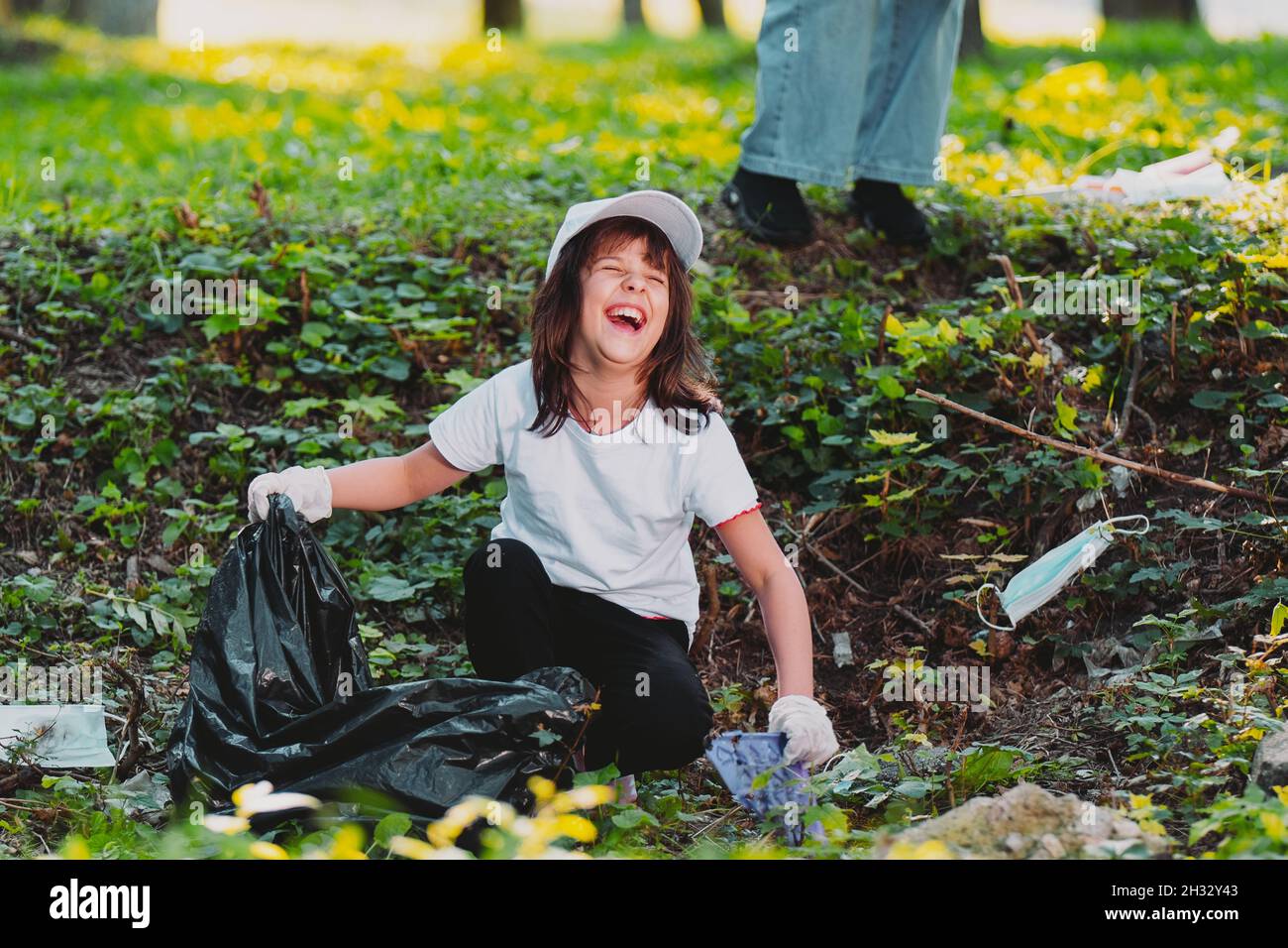 Close up photo of a laughing young girl sitting down on the ground in ...