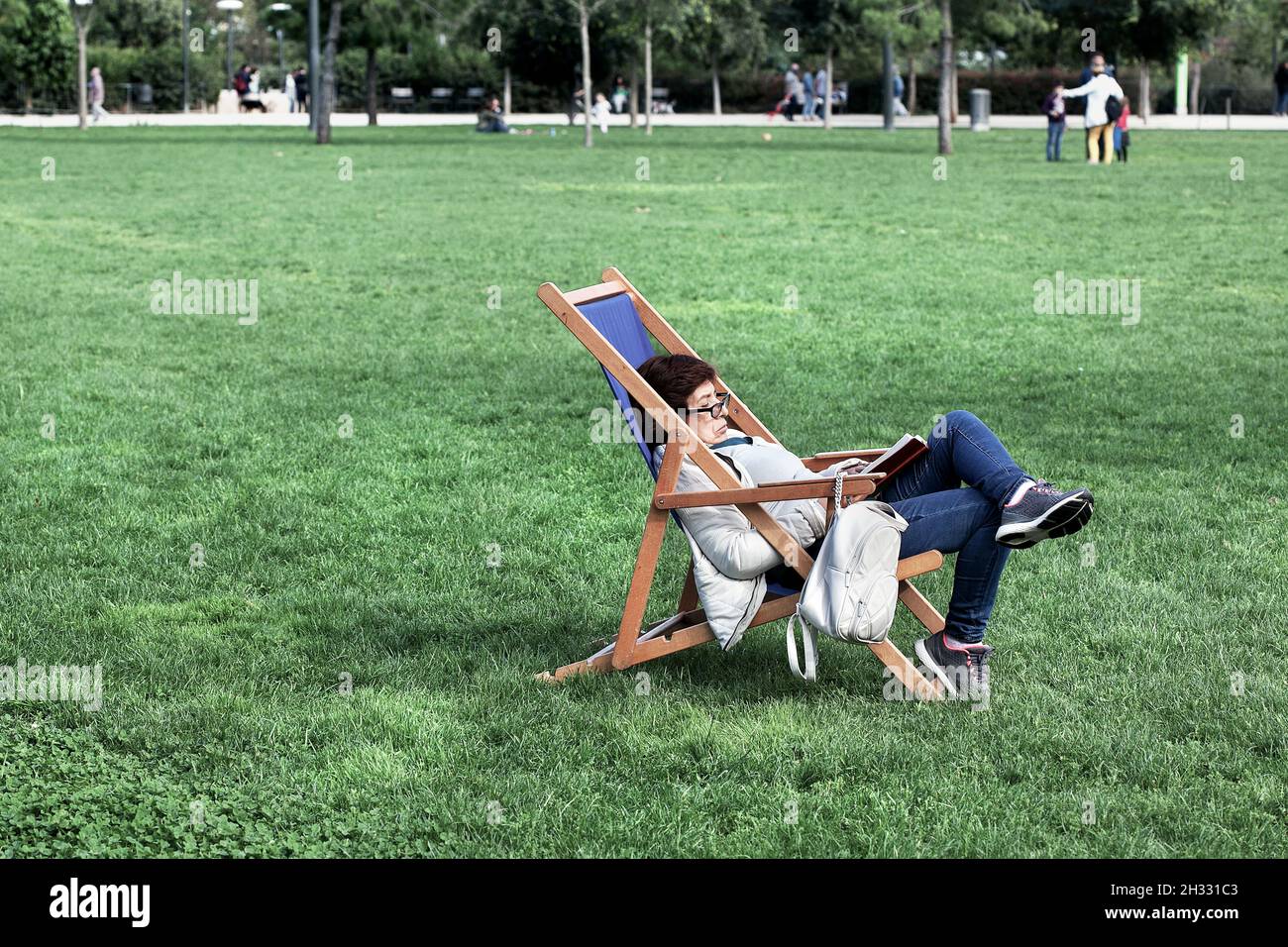 Woman slumped in deckchair, reading Stock Photo - Alamy