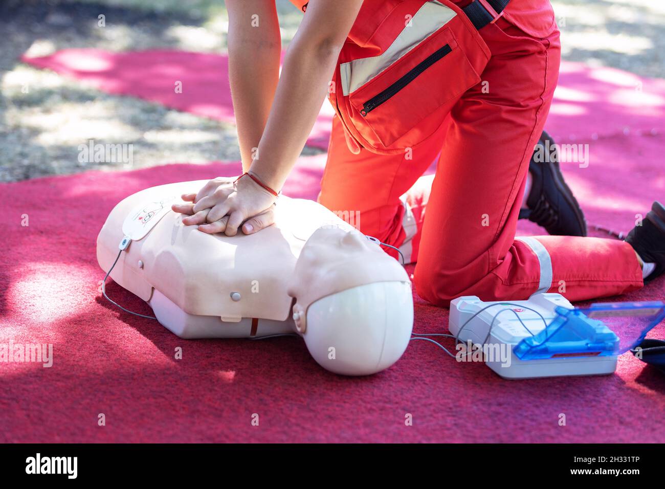 Hands of a paramedic doing chest compression during defibrillator CPR ...