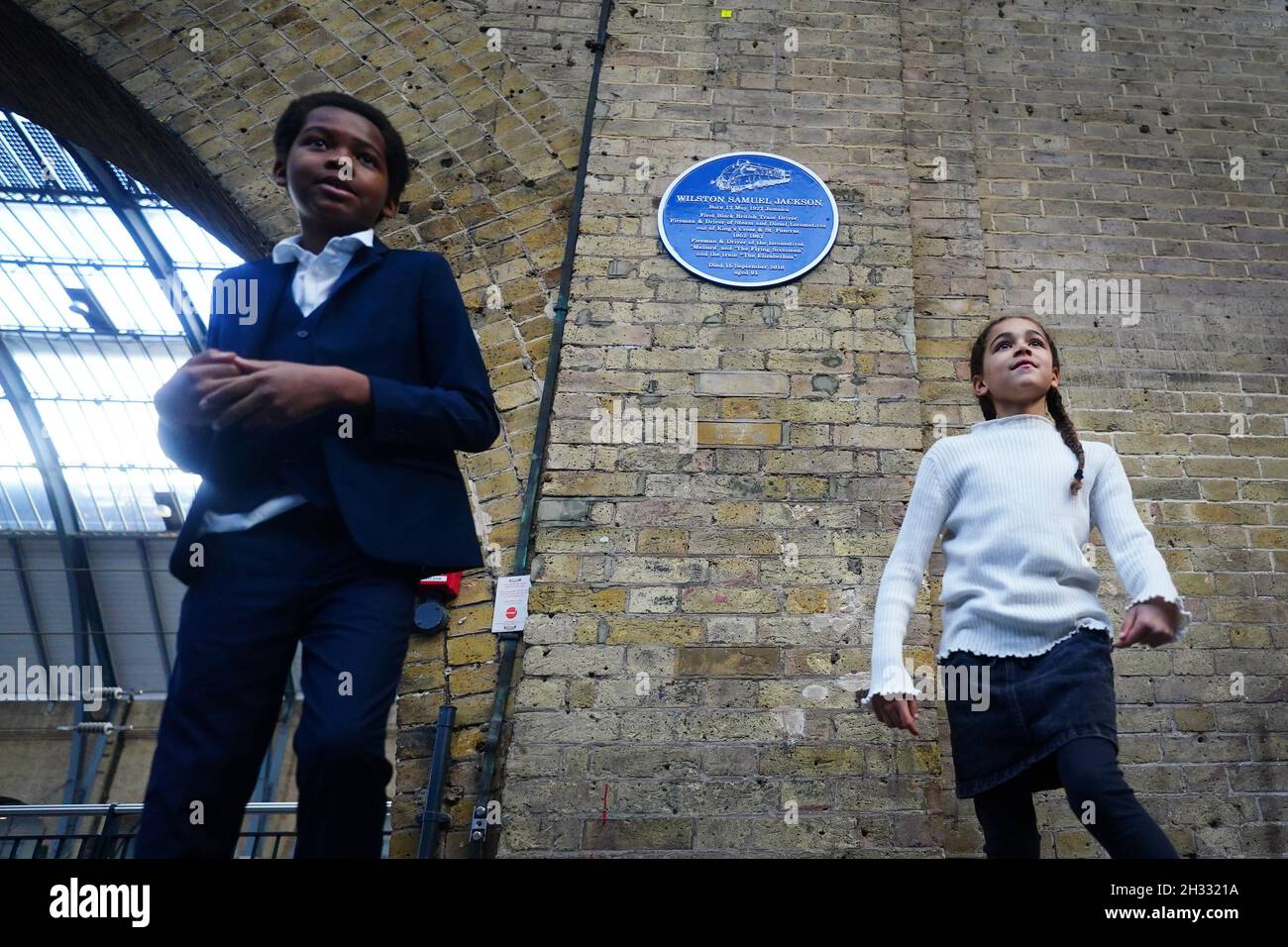 Josiah Jackson and Sofia Hollingsworth stand underneath a plaque to ...