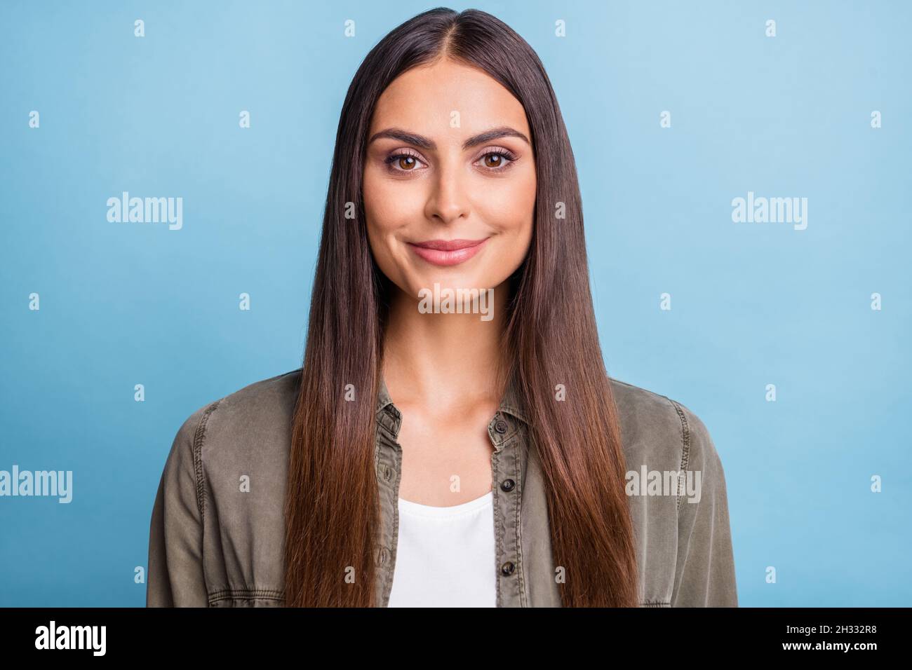 Photo of cute young brunette lady wear khaki shirt isolated on blue ...