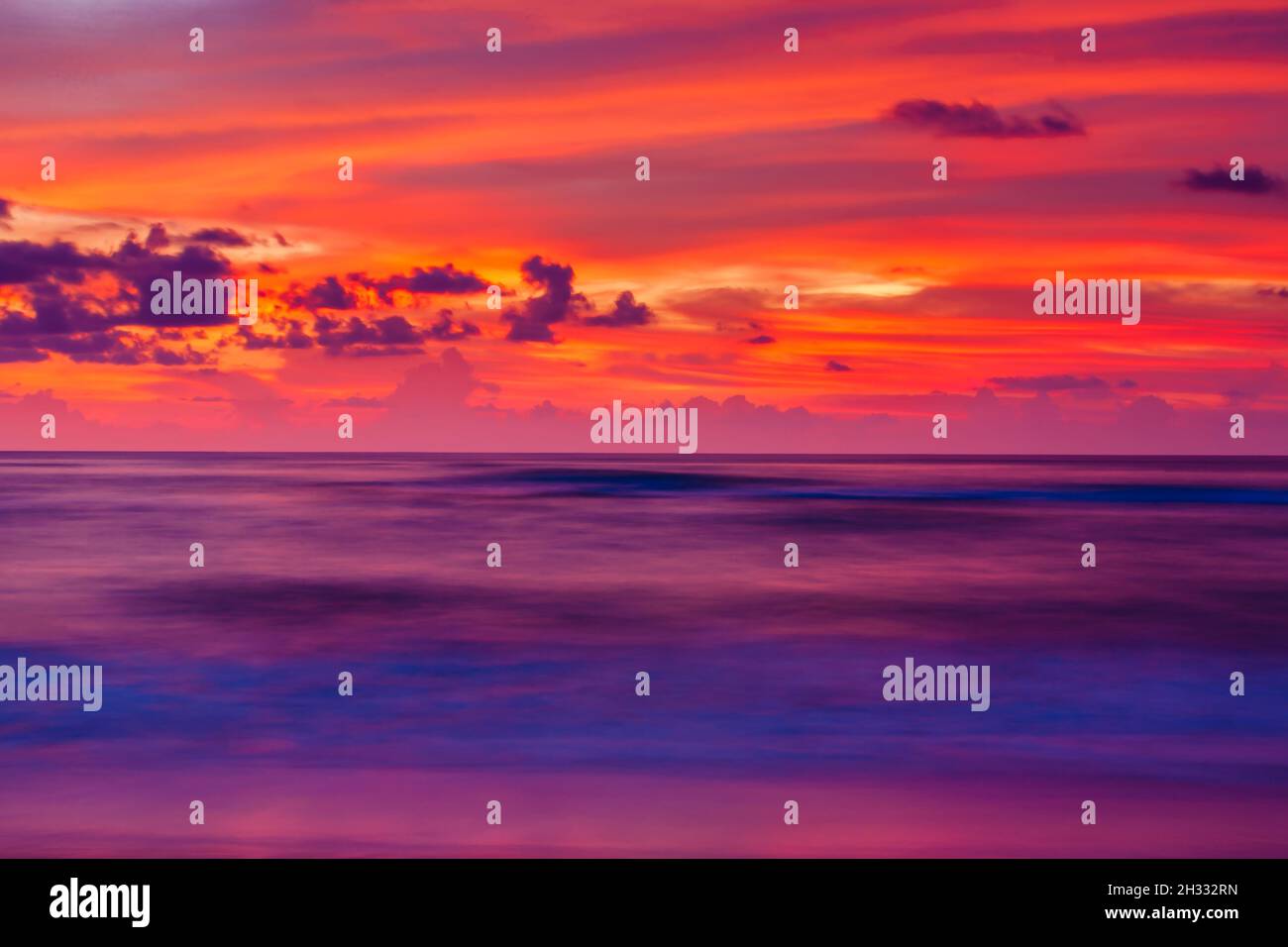 Seascape view of a tropical beach during sunset. Colourful sunset sky ...