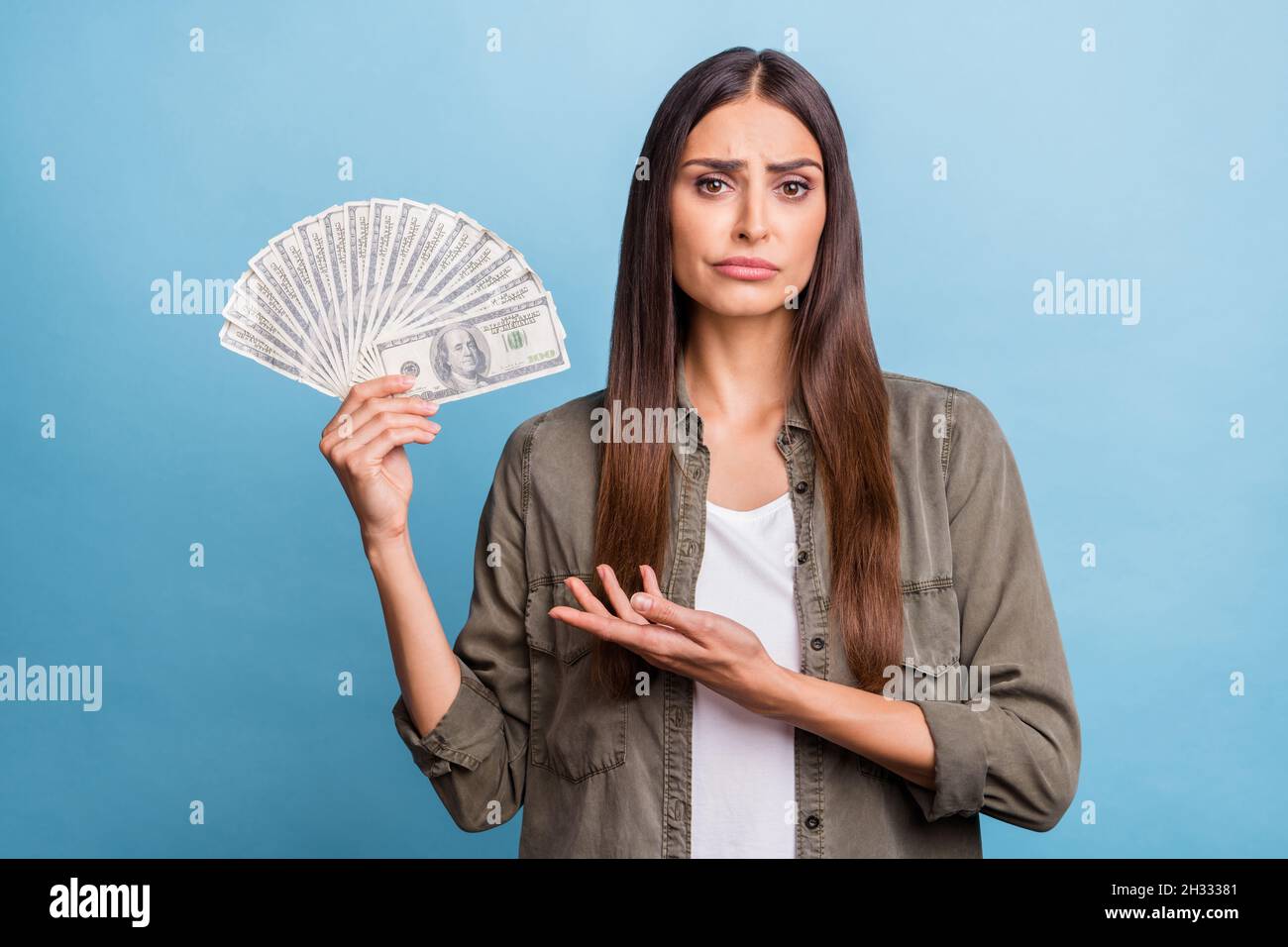 Photo portrait brunette woman grumpy keeping dollars stack isolated ...
