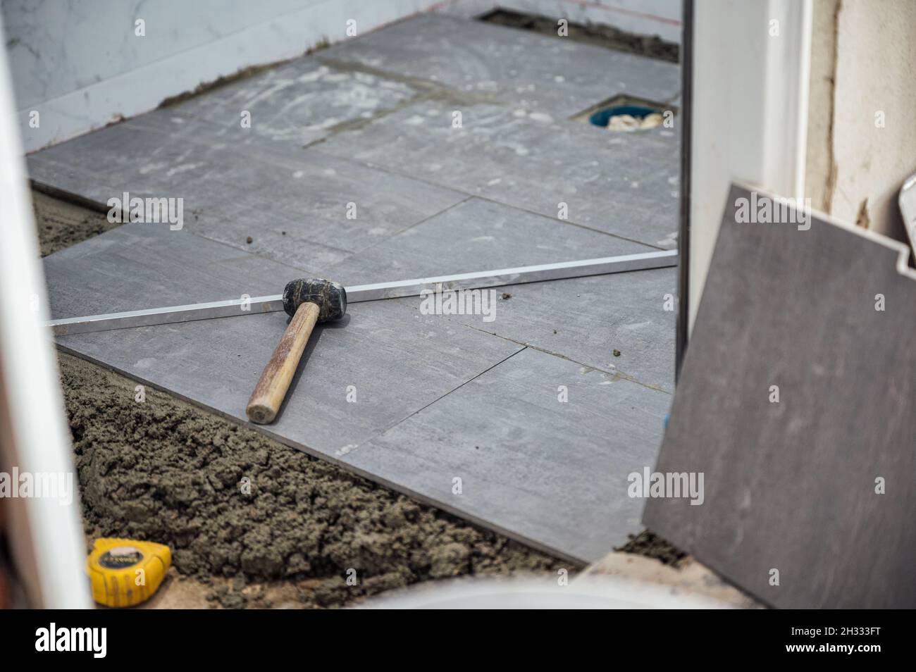 Mallet and tools on granite tile during laying floor Stock Photo - Alamy