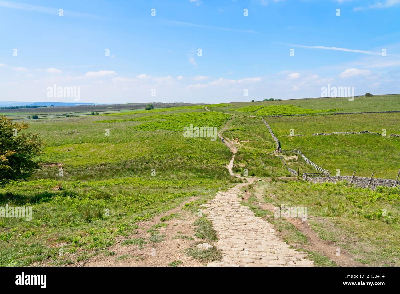 Uneven cobbled footpath down a steep hill then winding up and across ...
