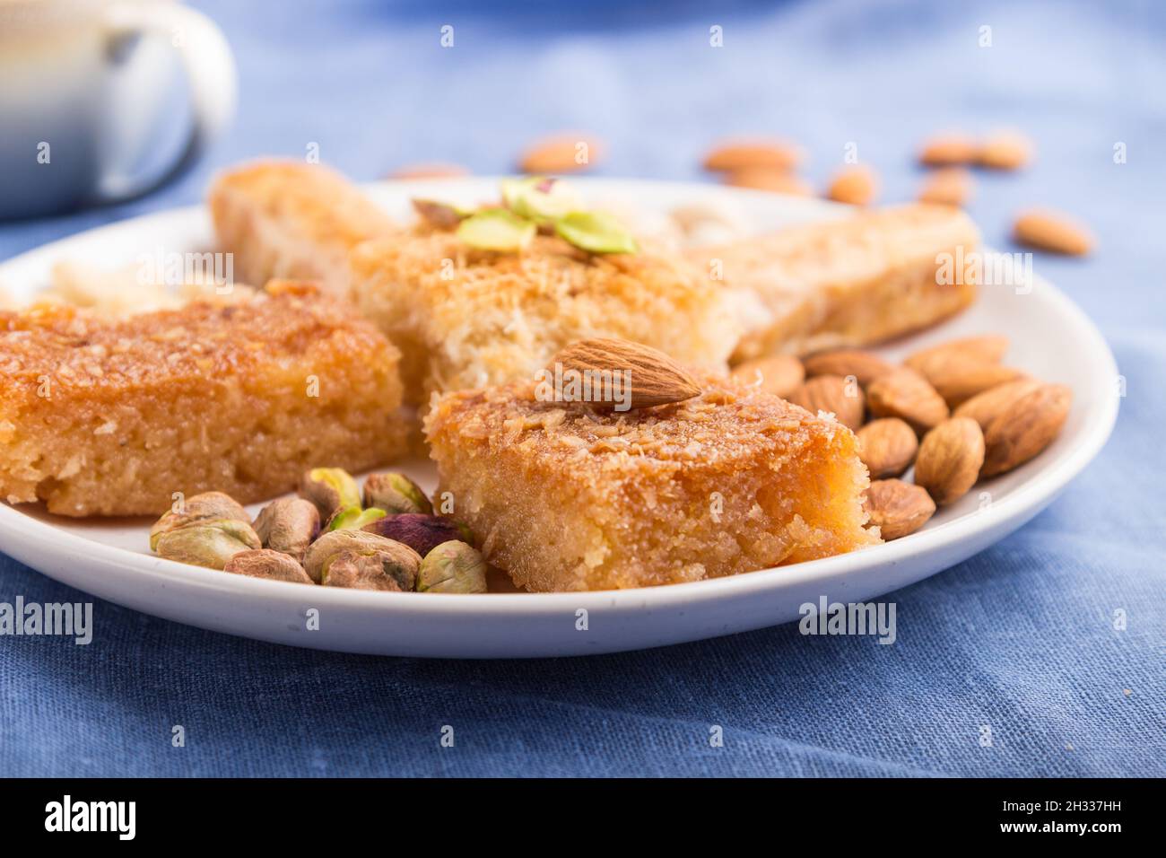 traditional arabic sweets (basbus, kunafa, baklava), a cup of coffee ...