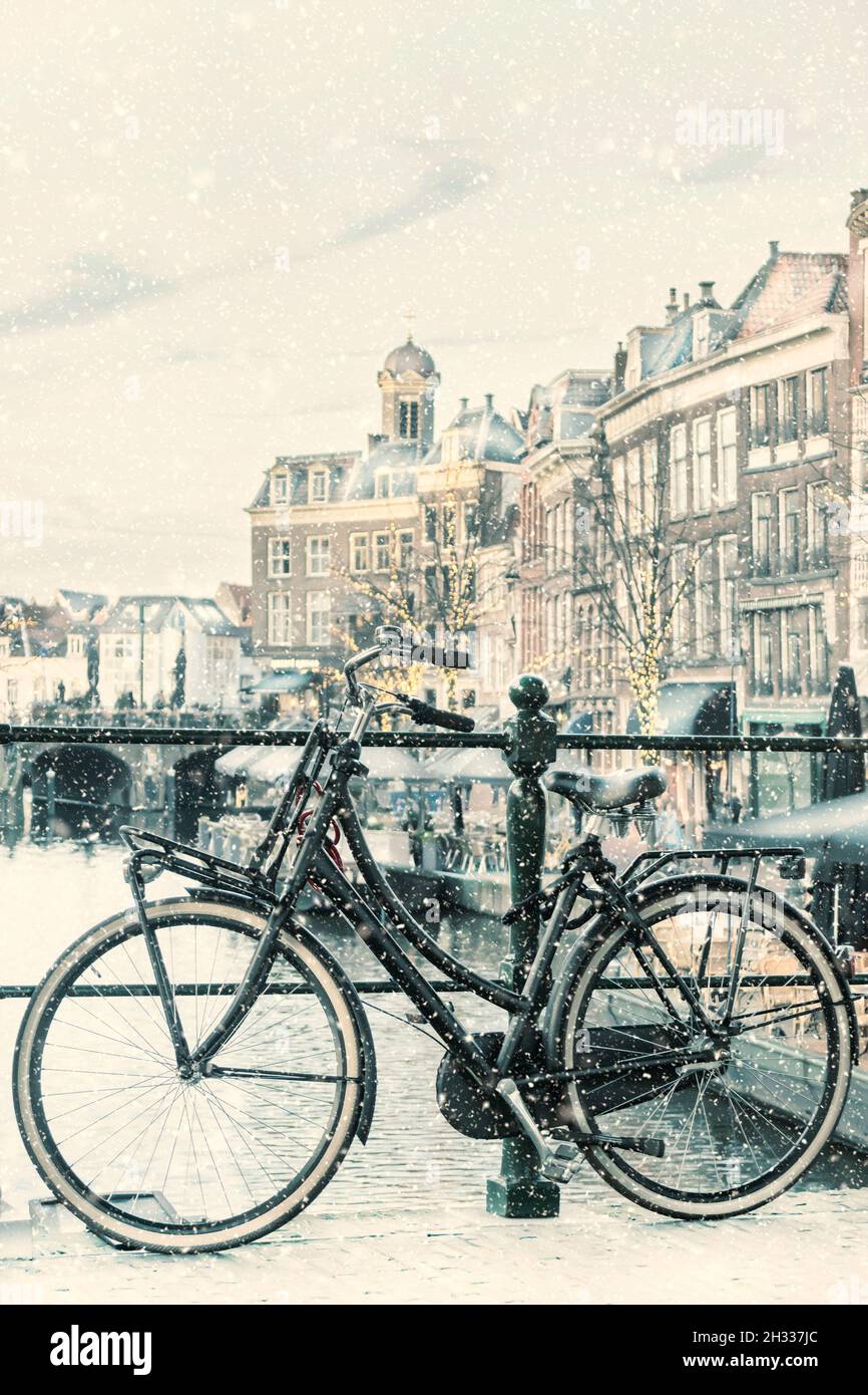 Winter view with snowfall of the Dutch Nieuwe Rijn canal with bridge ...
