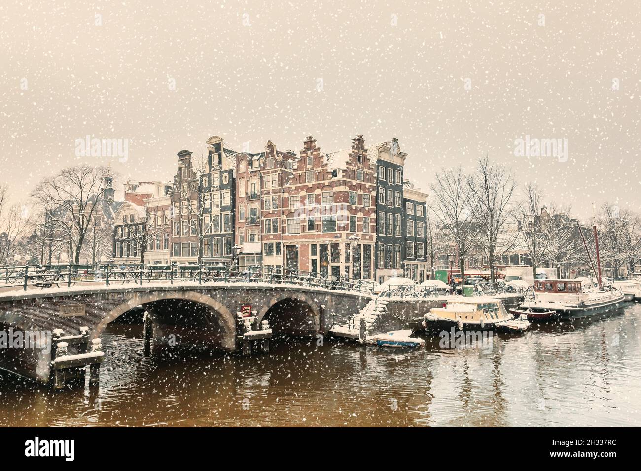 Winter snow view of Dutch canal and old houses in the historic city of ...