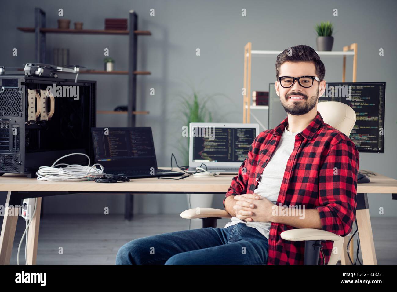 Portrait of attractive smart cheerful guy hacker programming code security data remote ...