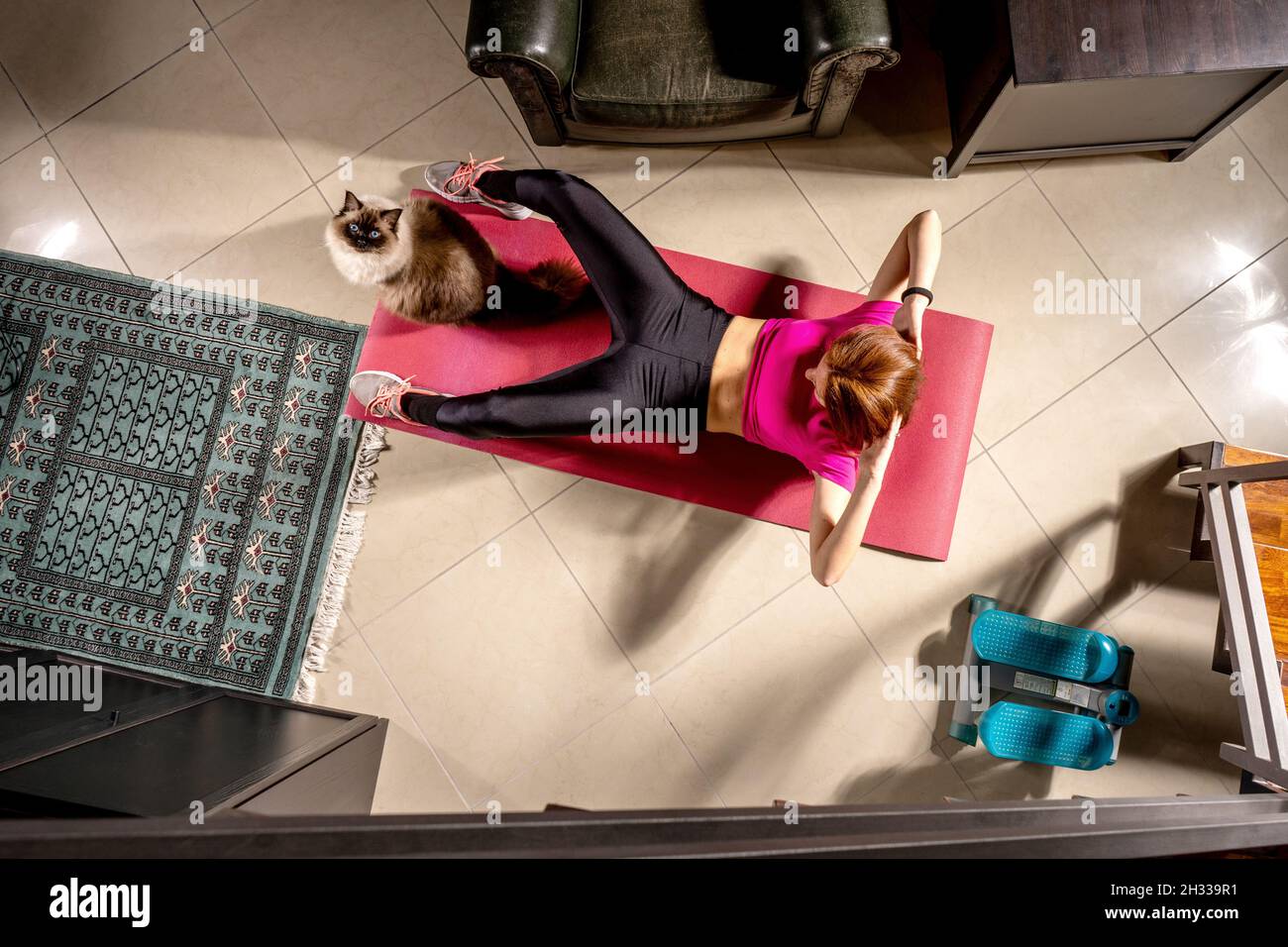 Attractive red hair sportswoman training in her beautiful house doing ...