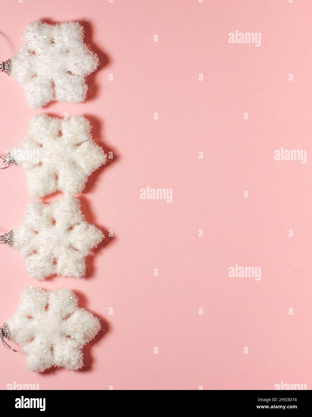 White snowflakes with glitter on a bright pink background on the left ...