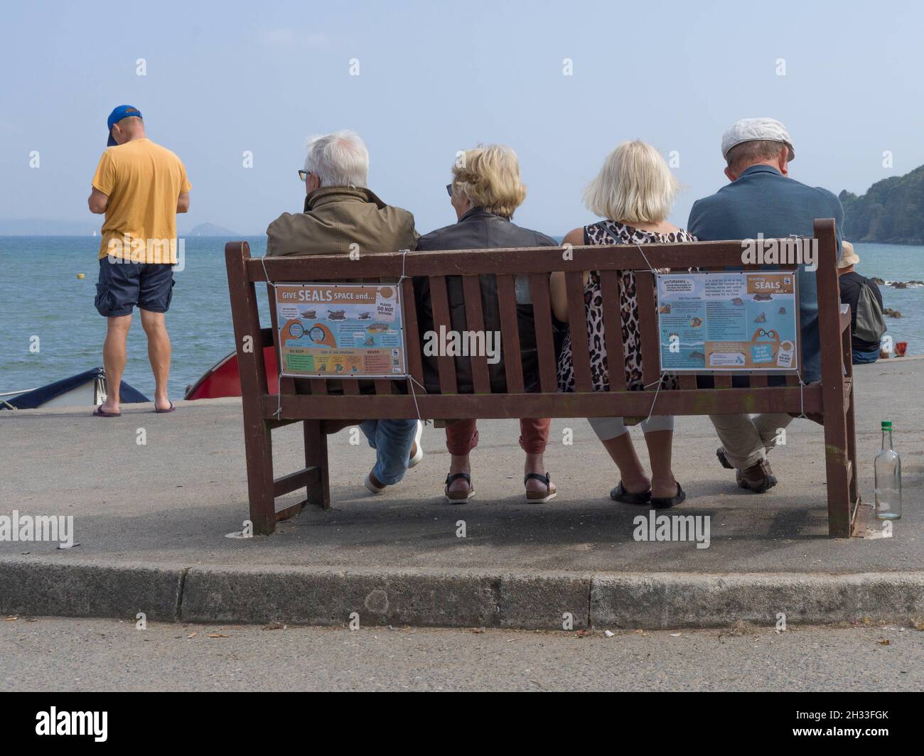 Four Sitting on a Bench Stock Photo - Alamy