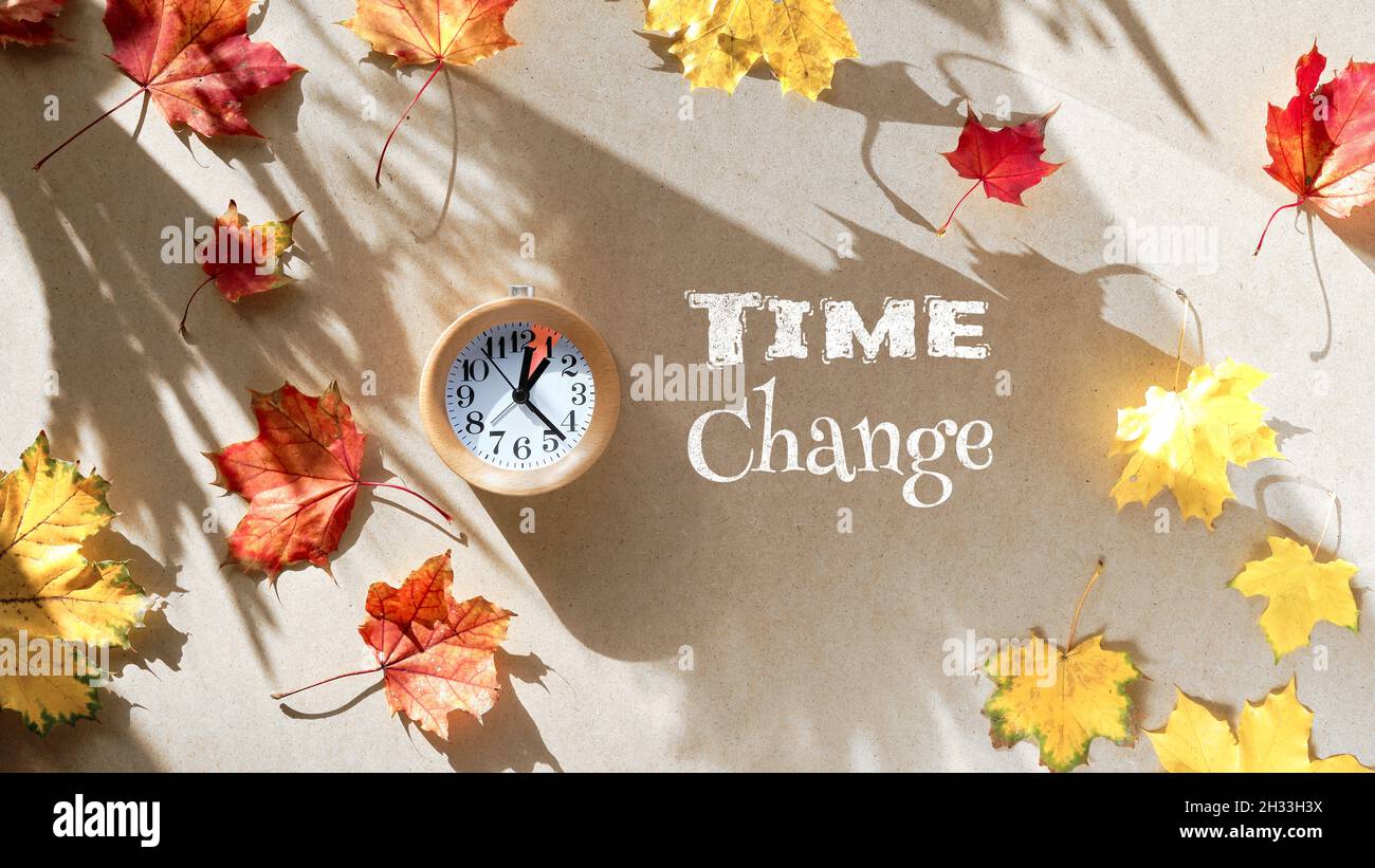 Time change in Autumn. Wooden alarm clock with one hour mark with dry ...