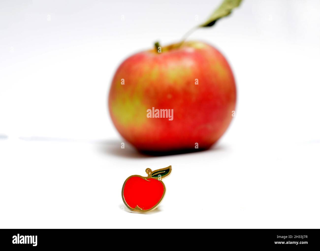 Red apple pin badge on white background Stock Photo - Alamy